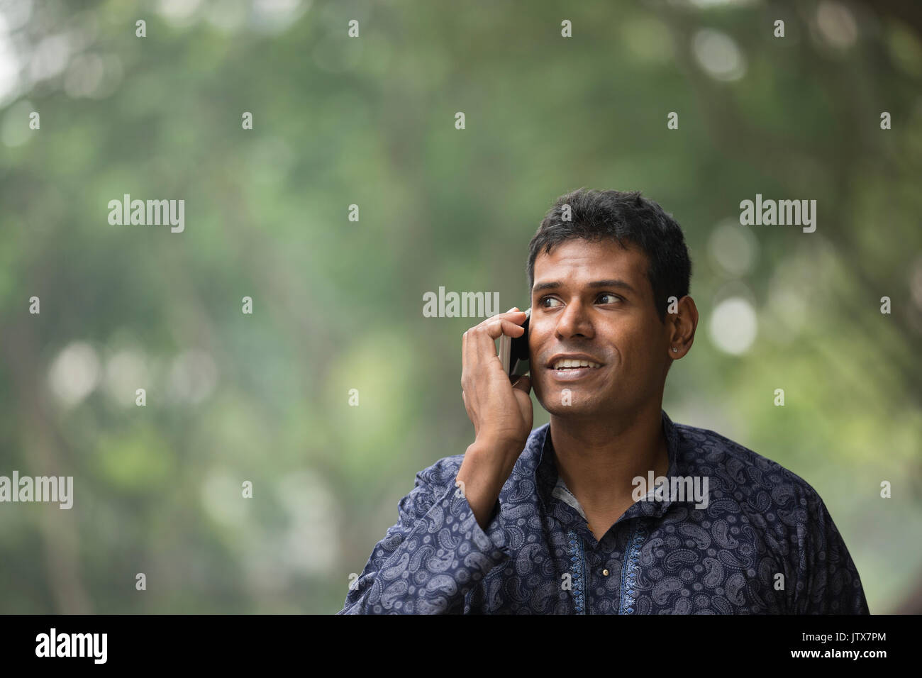 Happy Indian man using a smart phone on street. Traditional indian male ...