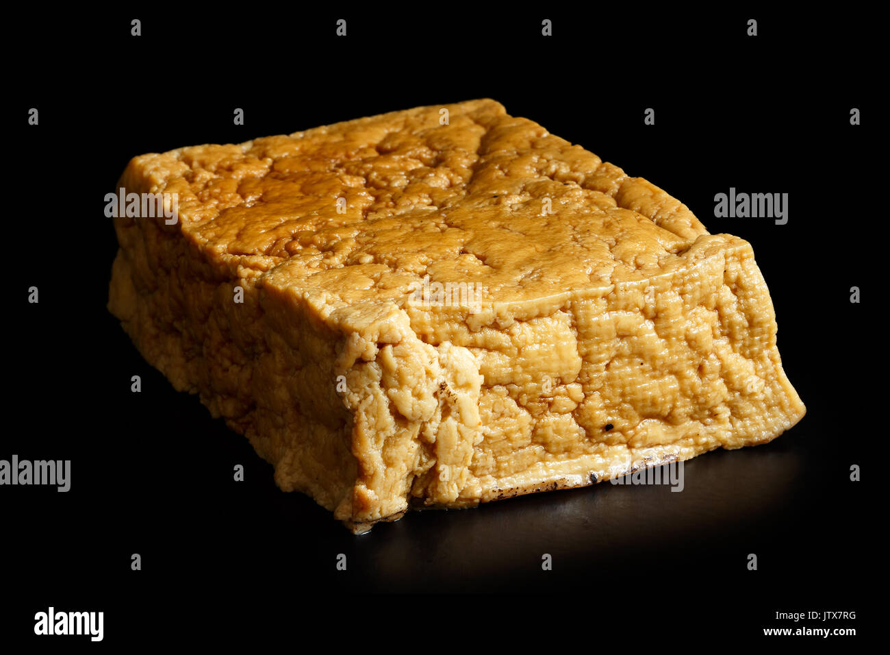 Single block of smoked tofu isolated on black Stock Photo - Alamy