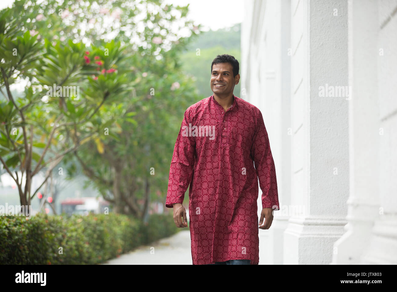 Happy indian man walking outdoors. Portrait of an indian man wearing a ...