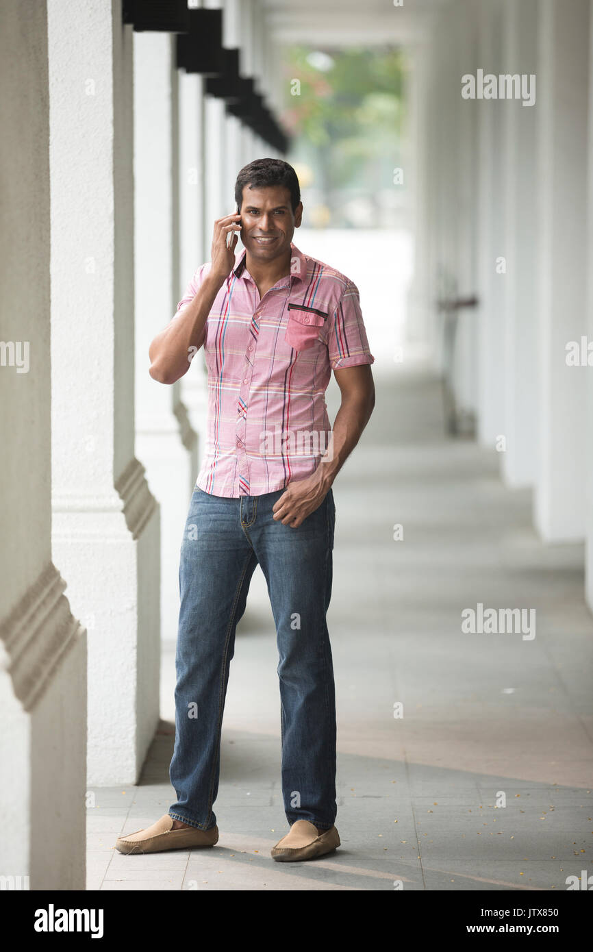 Happy Indian man using a smart phone on street Stock Photo - Alamy