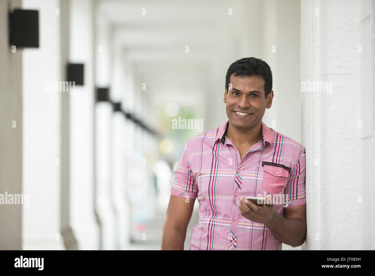 Happy Indian man using a smart phone on street Stock Photo - Alamy