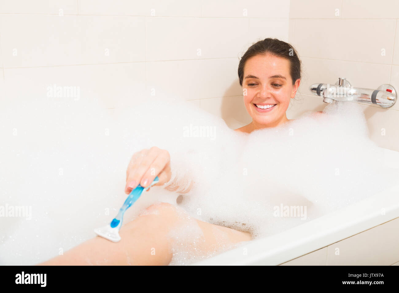 Young woman shaving legs bath spa water hi-res stock photography and ...