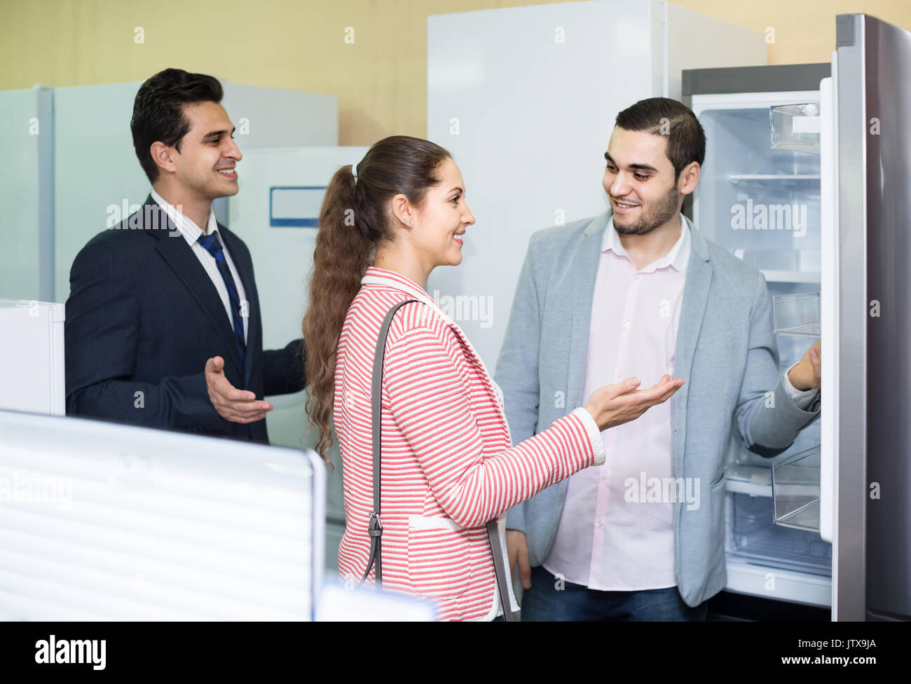 positive russian couple choosing new refrigerator in hypermarket and ...