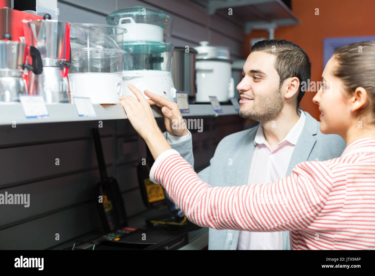 Positive salesman and adult customer in interior Stock Photo - Alamy