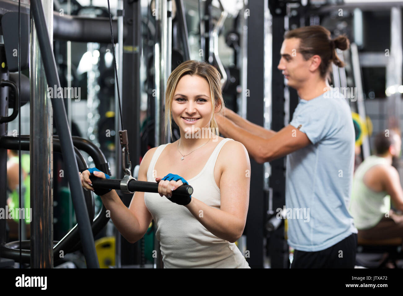 Adults having strength training under coach control in gym Stock Photo ...