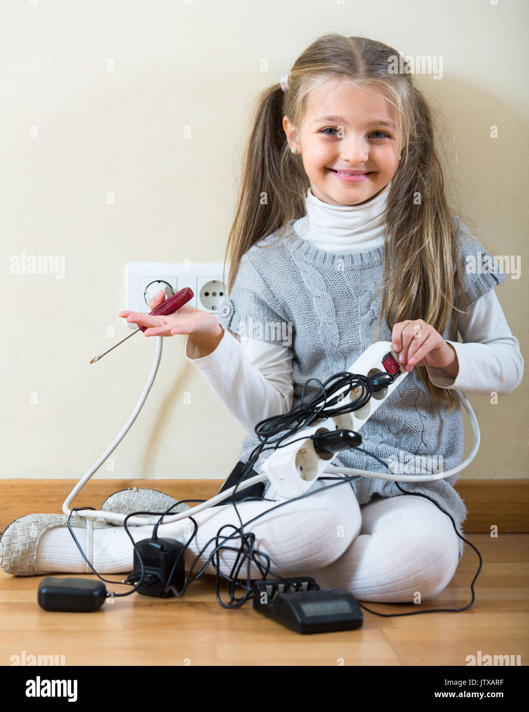 Risky little girl dangerously playing with sockets and electricity ...