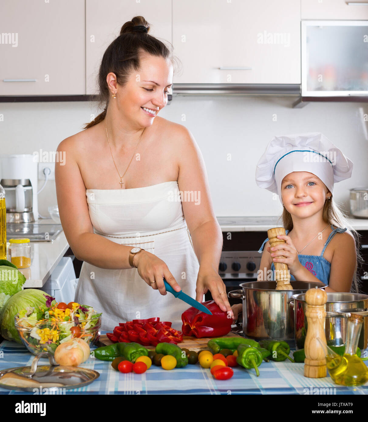 Happy woman and her daughter cooking healthy dinner Stock Photo - Alamy
