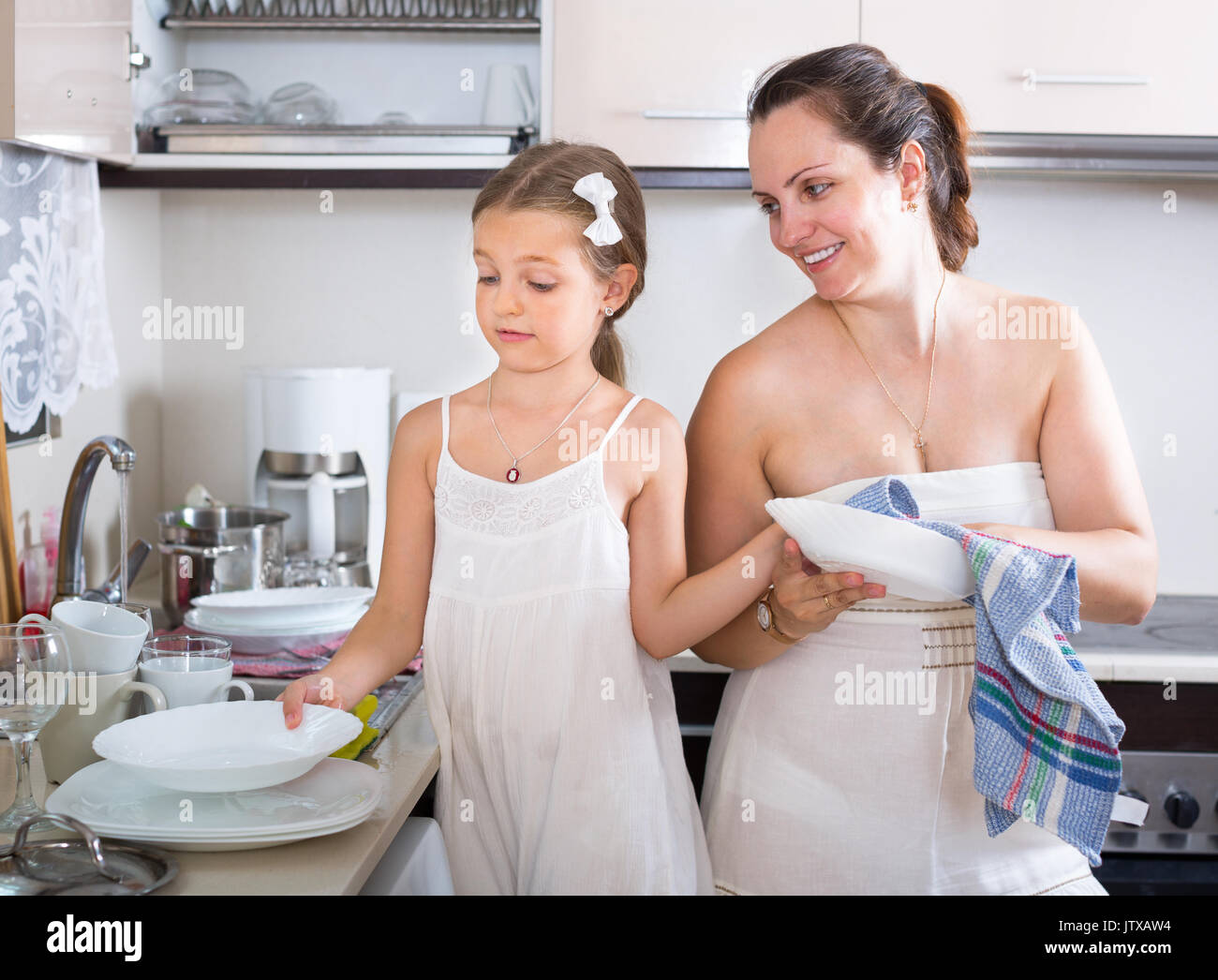 little girl washing plates with happy mother at domestic kitchen Stock ...
