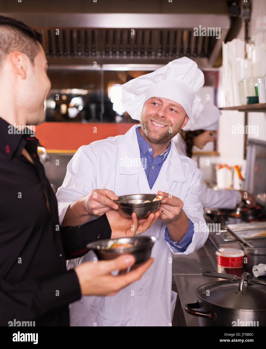 Happy chefs and waiter working at eating house Stock Photo - Alamy