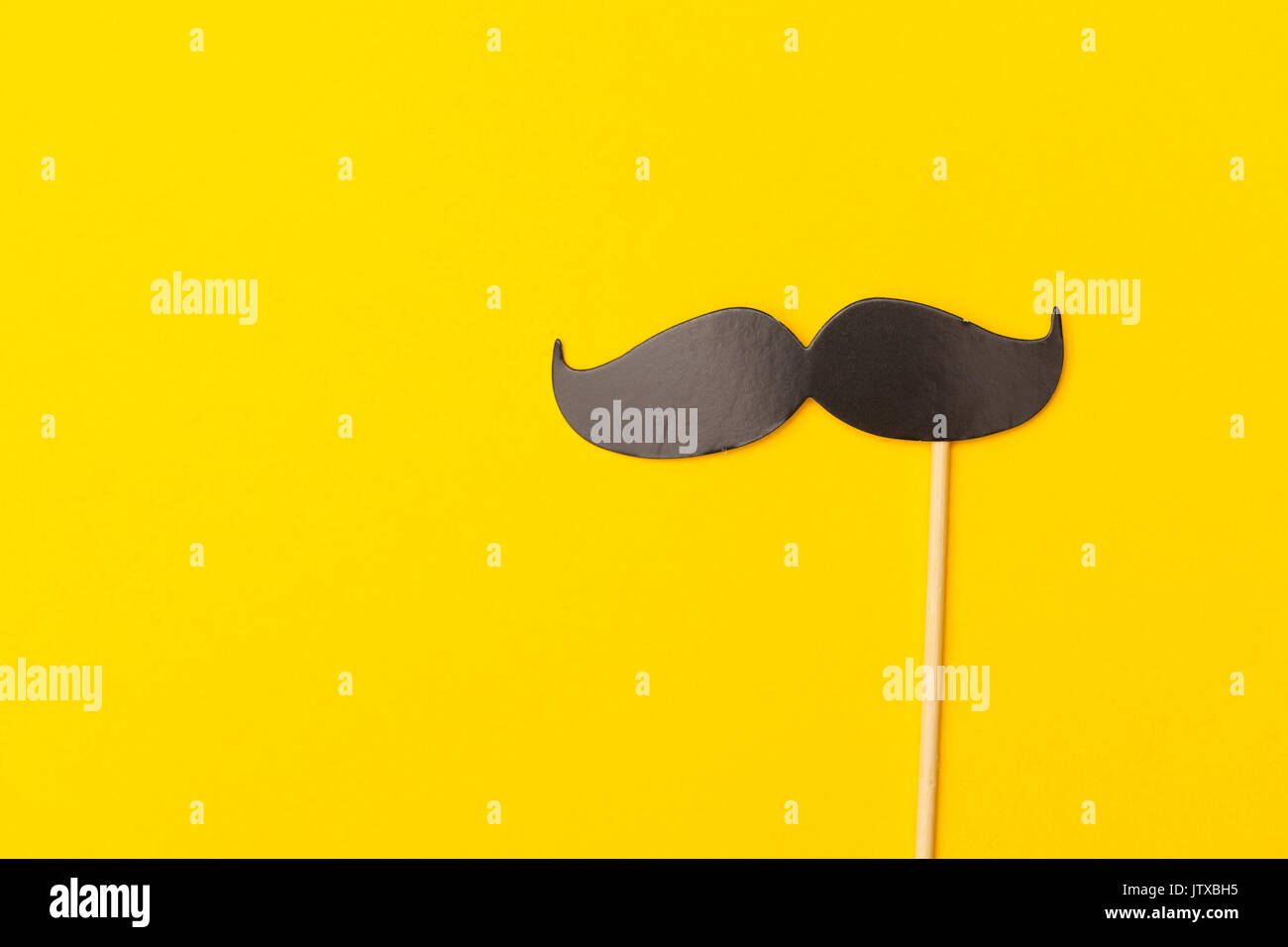 Moustache on a stick on a bright yellow background Stock Photo - Alamy