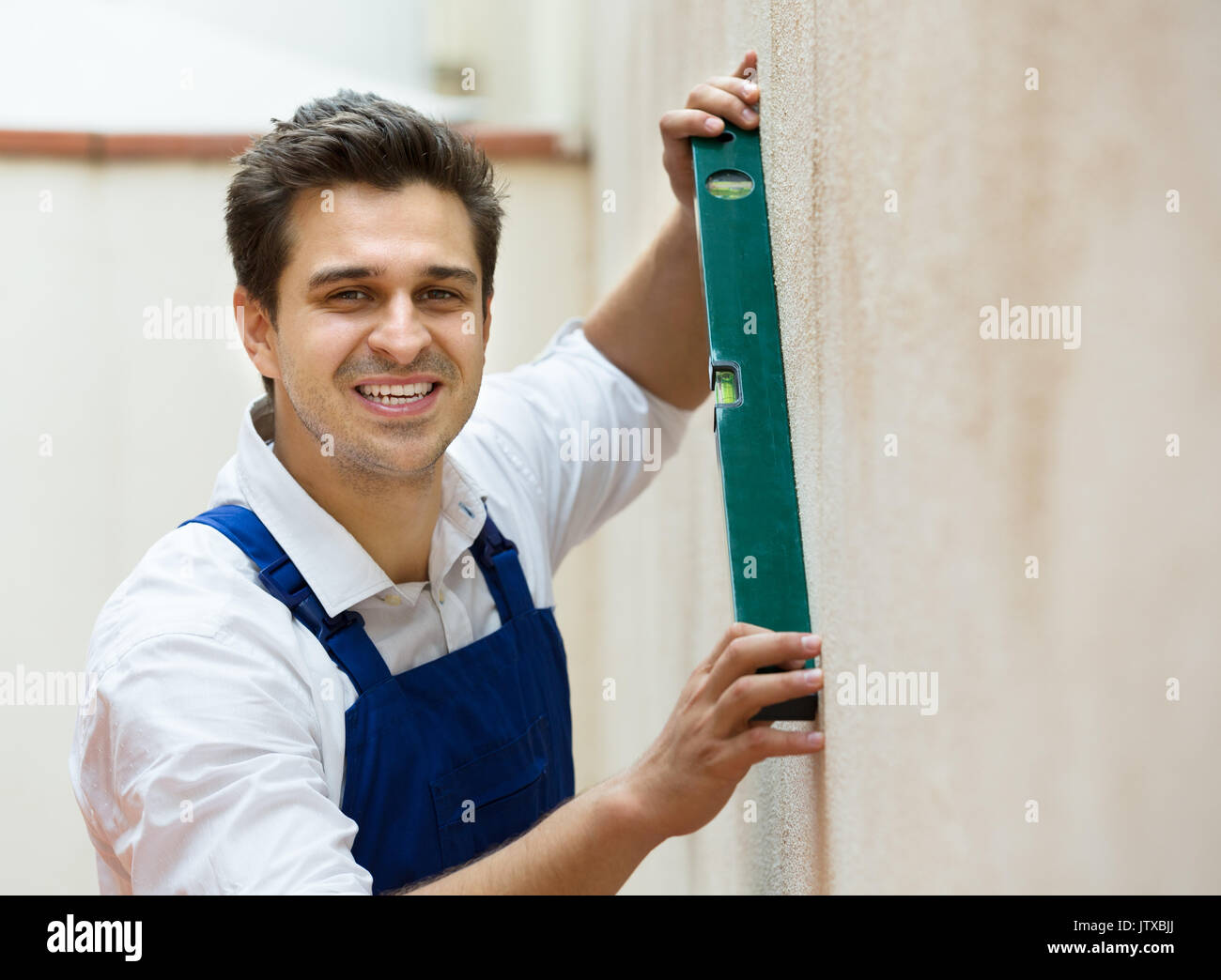 Professional male posing with spirit level at construction site Stock ...