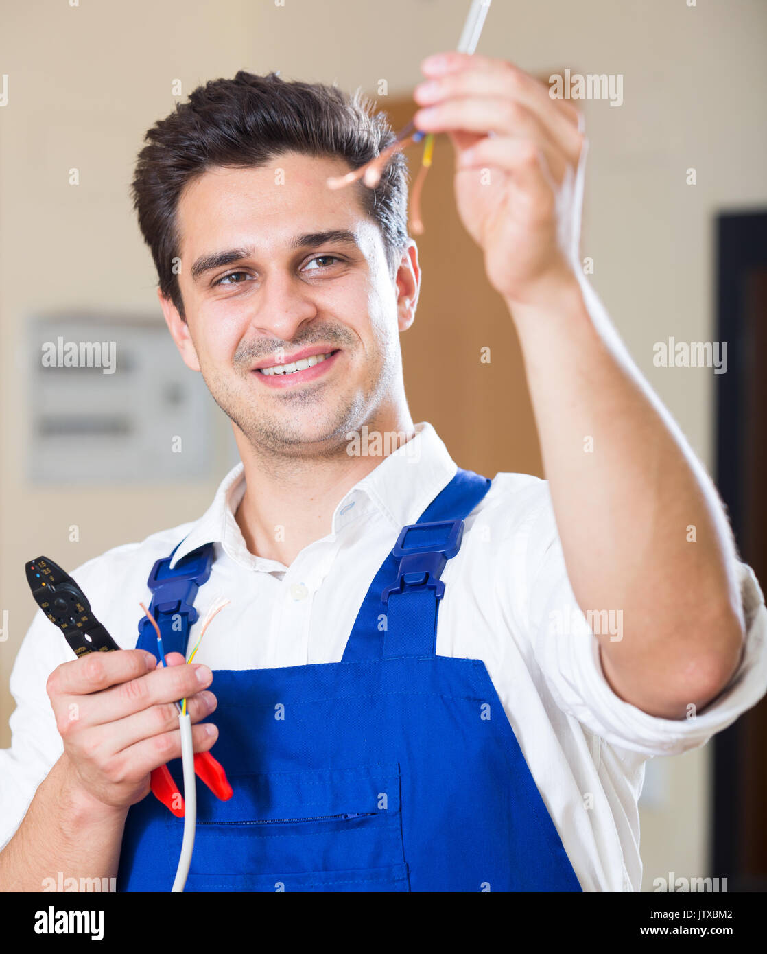 Young professional fixing indoor wiring in new building Stock Photo - Alamy
