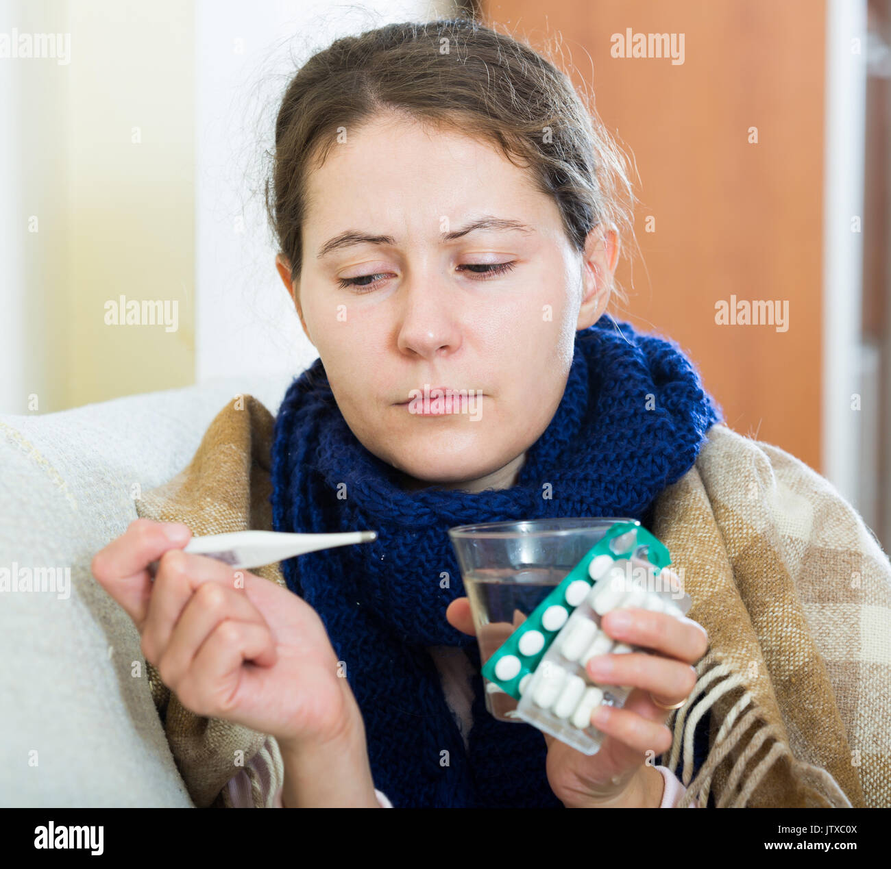 Young spanish brunette sick with fever under blanket in domestic ...