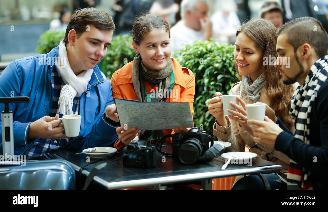 adult european tourists drinking coffee at cafe and reading city map ...