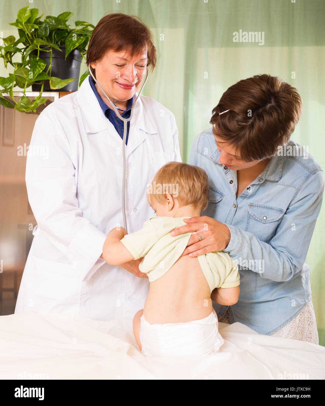 Happy female pediatrician doctor examining baby at clinic office Stock ...