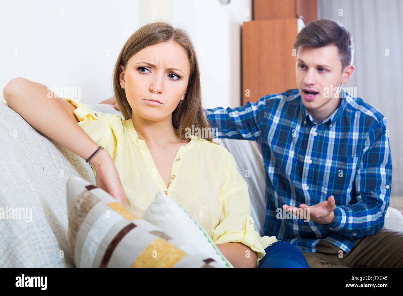 Young american family couple with serious faces quarrelling at home ...