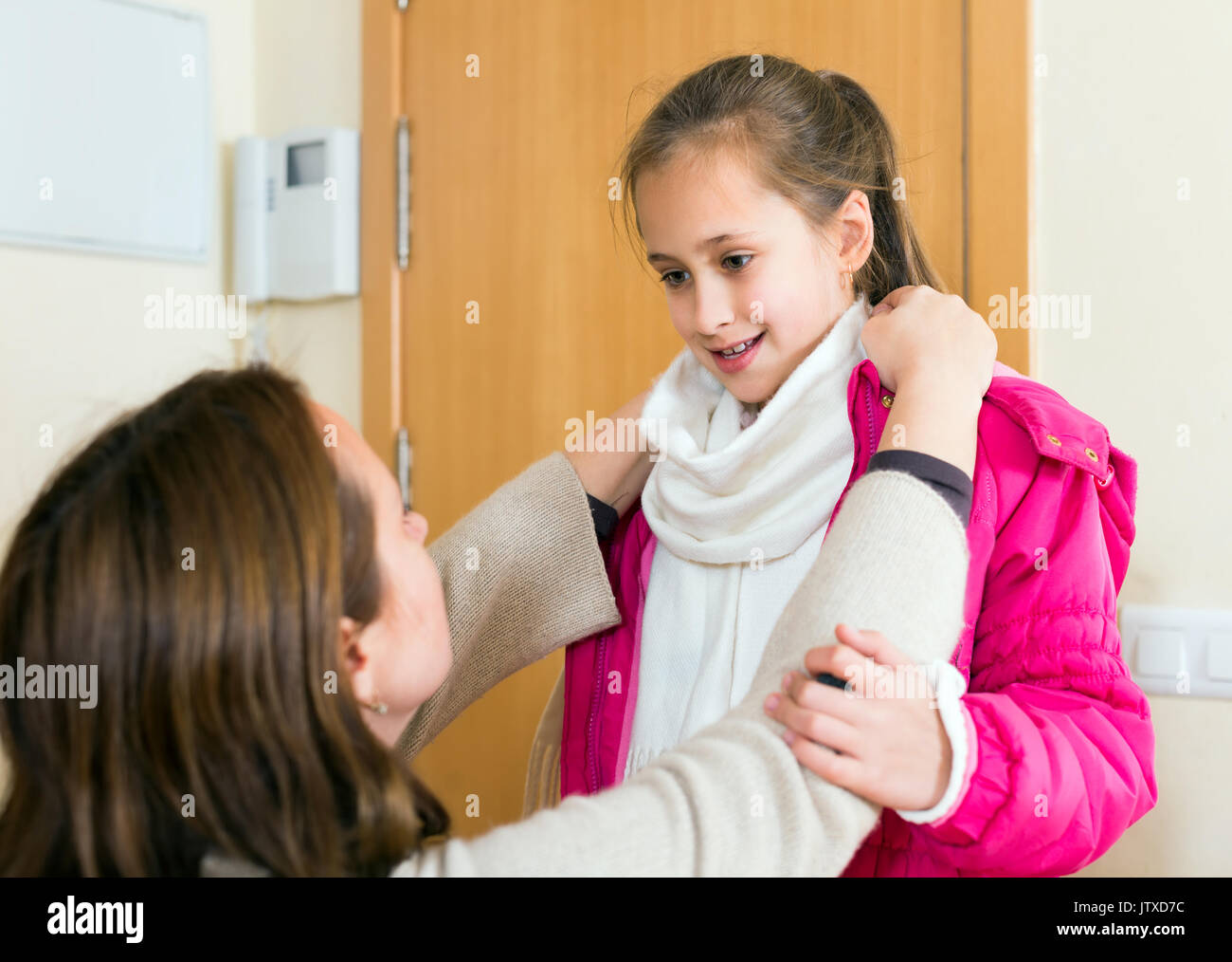 Caring mom helps her little daugher to dress Stock Photo - Alamy