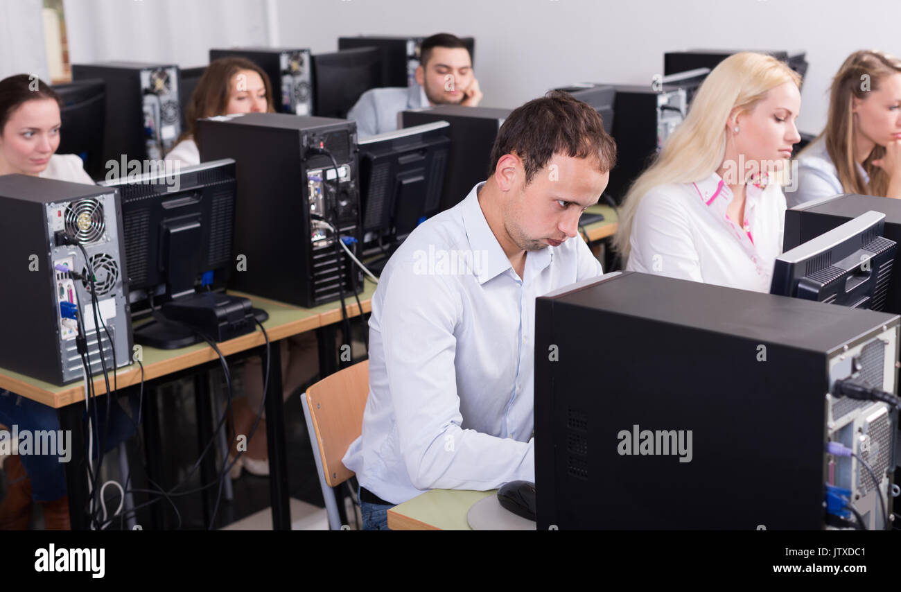 Bored russian staff sitting at desks and looking at PC screens Stock ...