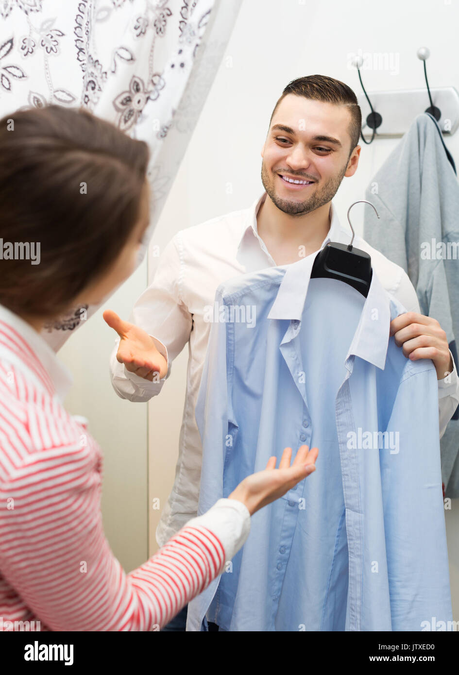 Happy young couple standing at boutique changing cubicle Stock Photo ...