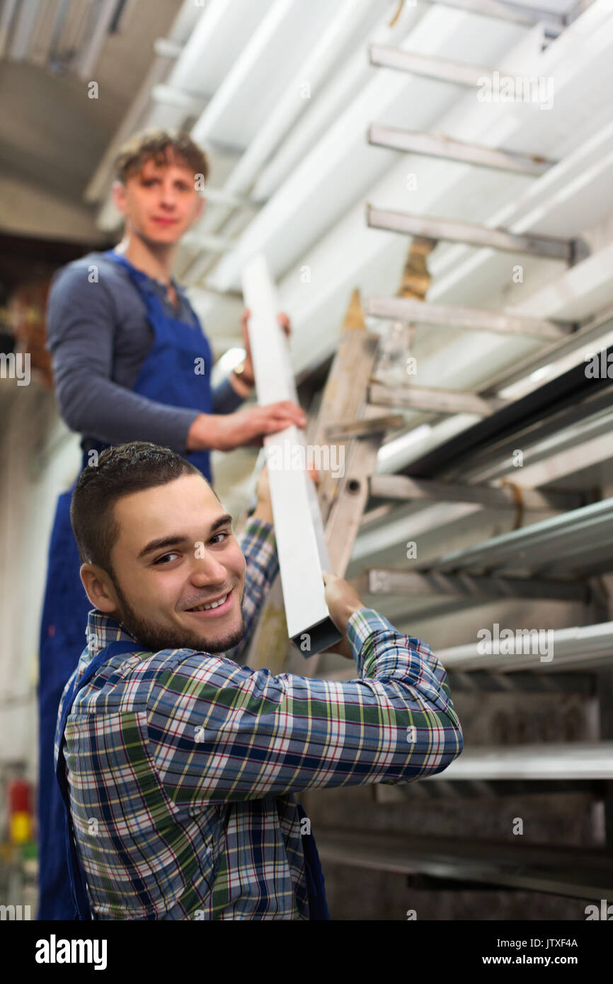 Production workers in uniform with different PVC window profiles indoor ...