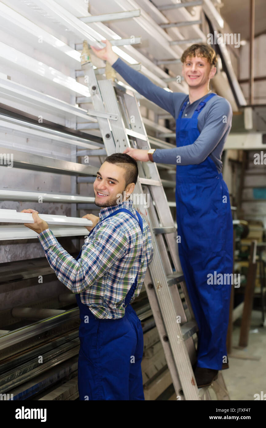 Couple of workers choosing window profiles at factory Stock Photo - Alamy