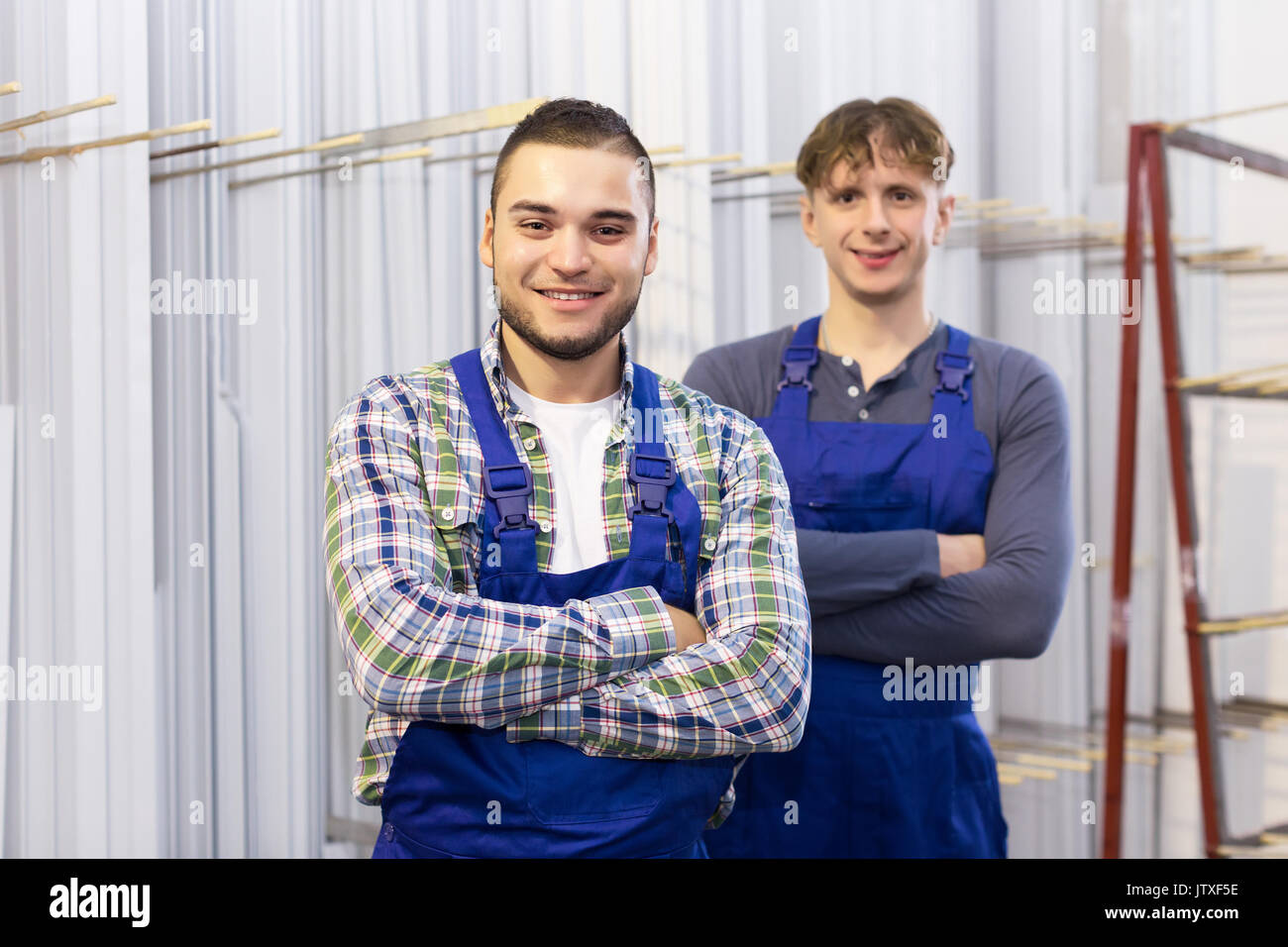 Happy people near PVC window frames at factory. Focus on left man Stock ...