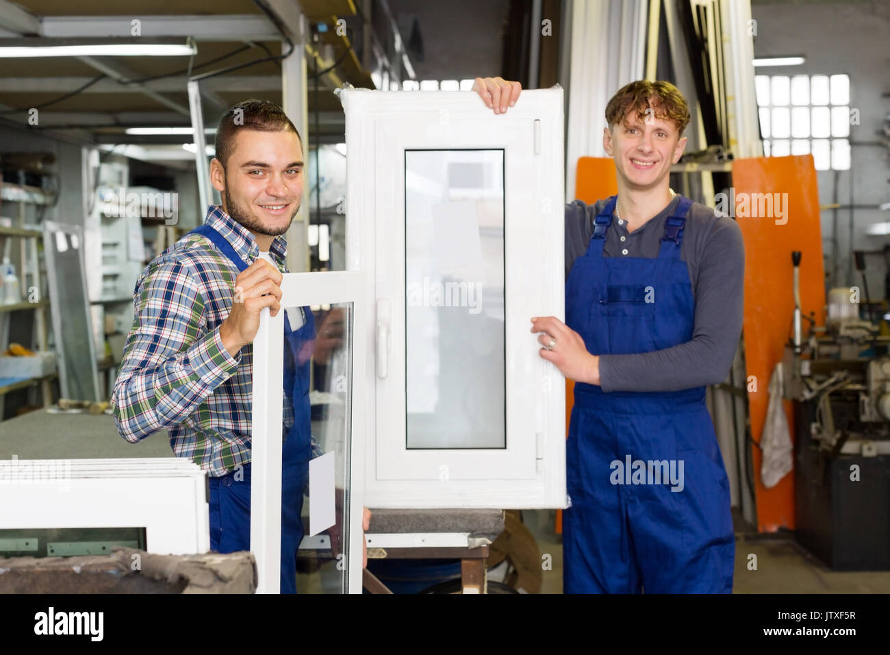 Production workers in blue coverall with different PVC window Stock ...