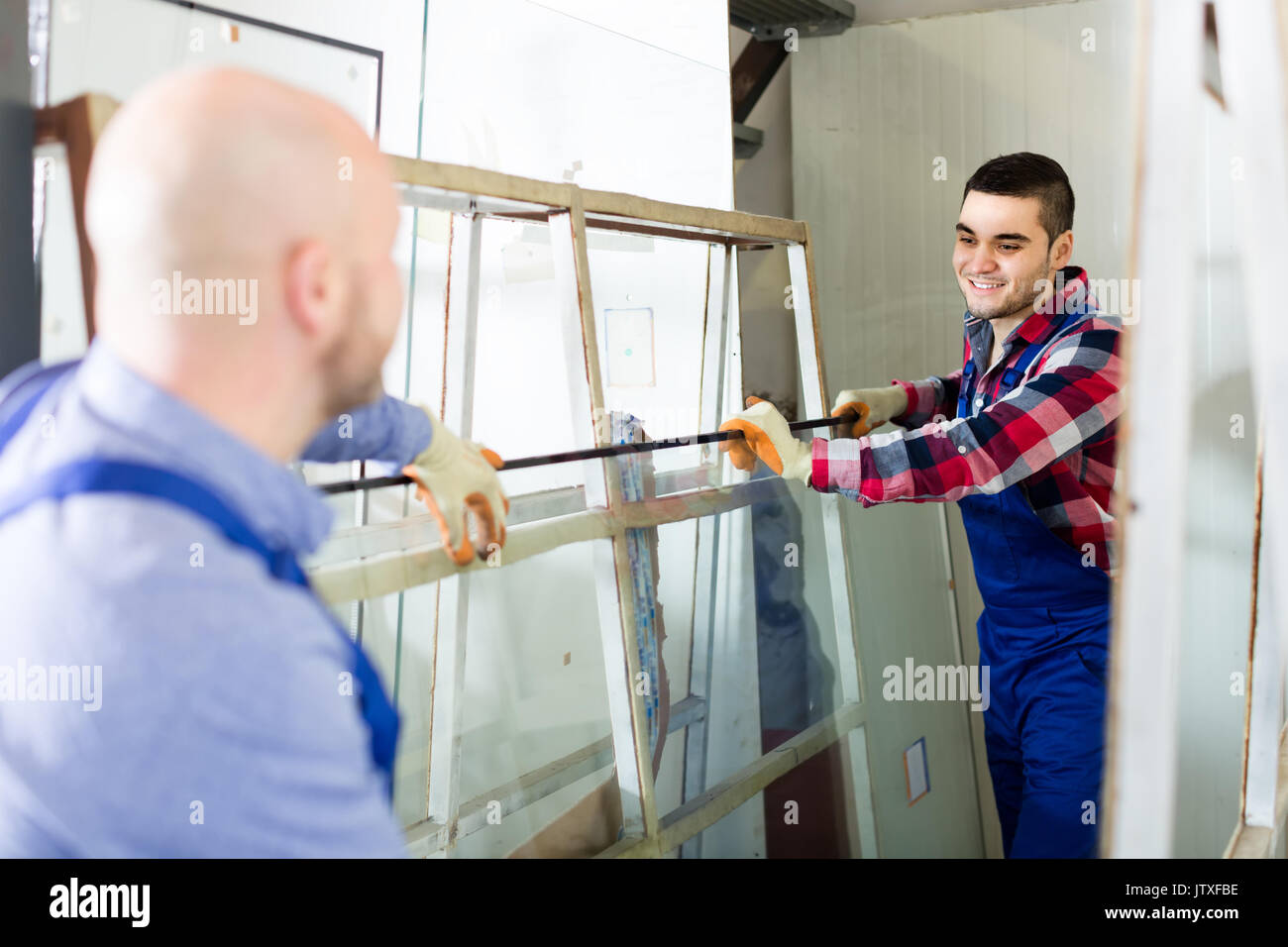 Two smiling production workers in coverall working with different PVC ...