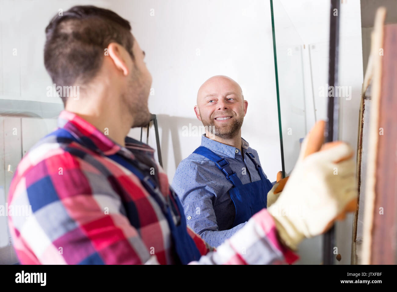 Two workers working with glass for windows at workshop Stock Photo - Alamy