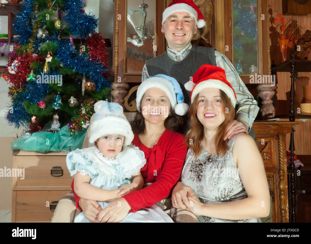 Happy family of three generations in santa hats celebrating Christmas ...
