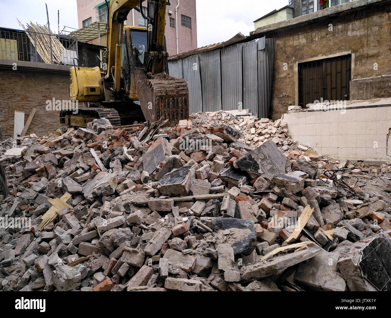 demolished concrete and brick rubble debris with excavator Stock Photo ...