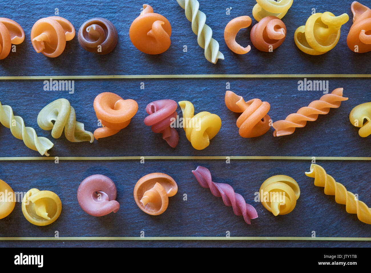 three rows of different kinds of pasta divided by thin long spaghetti ...