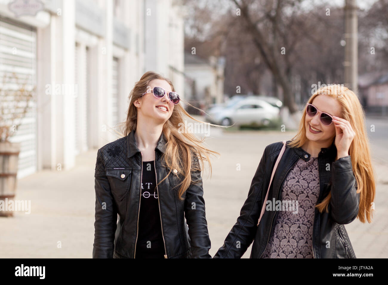 Two girl friends hanging out outside in the city Stock Photo - Alamy