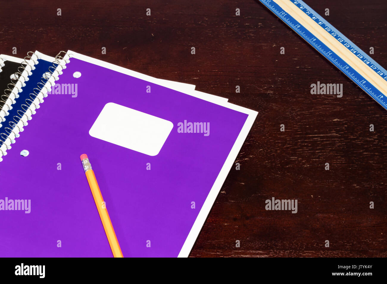 Multi colored notebooks ruler and pencil on a table Stock Photo - Alamy