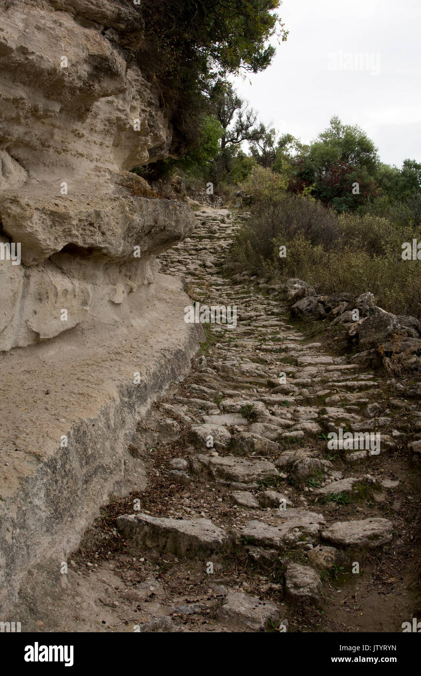 An ancient paved road leads from the entrance of the Roman place ...