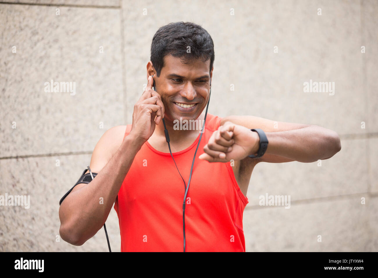 Sporty Indian man looking at his smartwatch heart rate monitor ...
