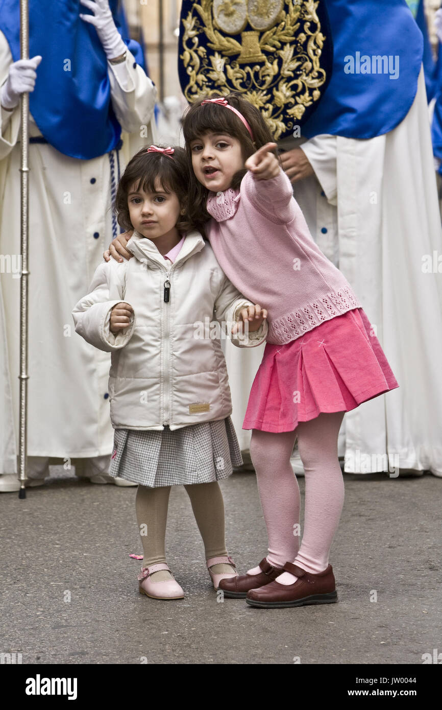 Two girls on the street watching procession of Holy Week, Andalusia ...