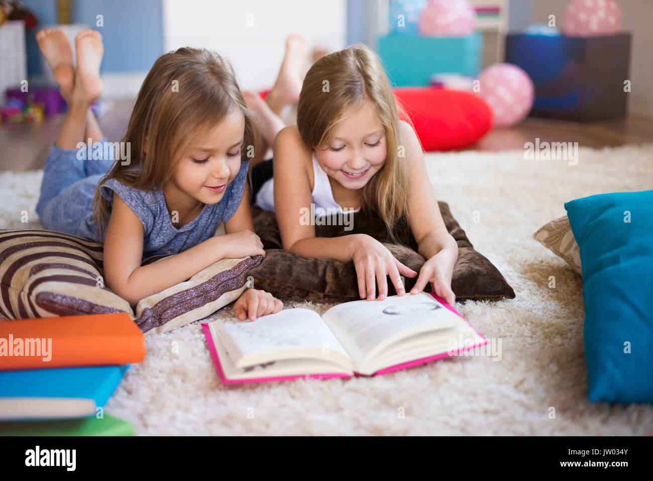 Reading interesting book with sister Stock Photo - Alamy