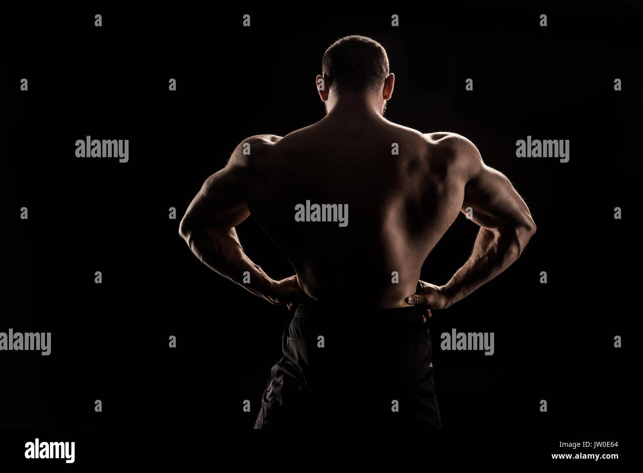 back view of young shirtless athlete flexing back muscles Stock Photo ...