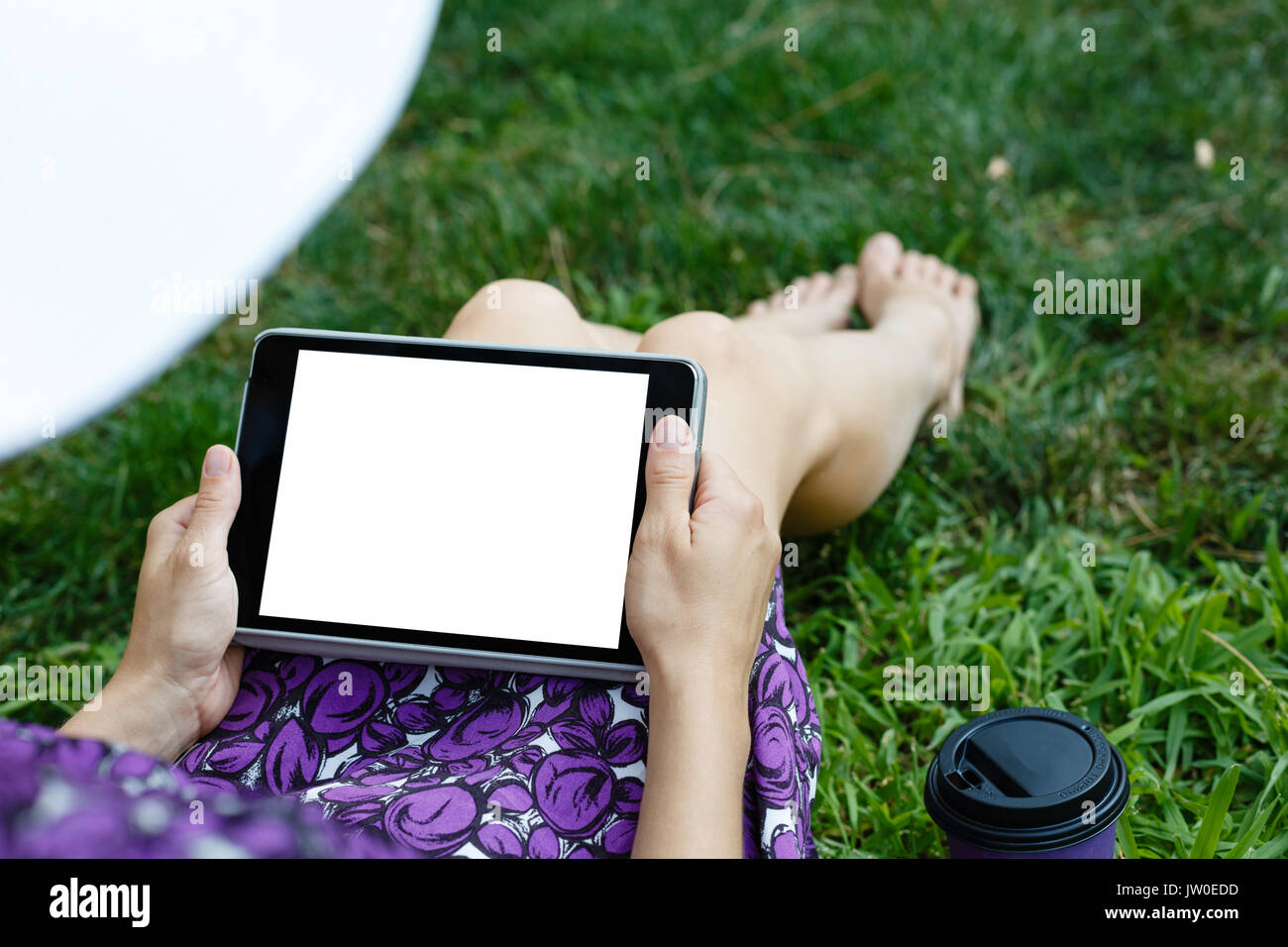 Anonymous woman in white hat and dress relaxing on green grass with ...