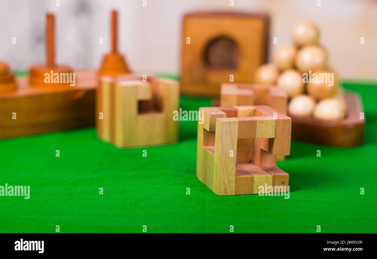 Wooden block brain teaser puzzle on green table in a blurred background ...