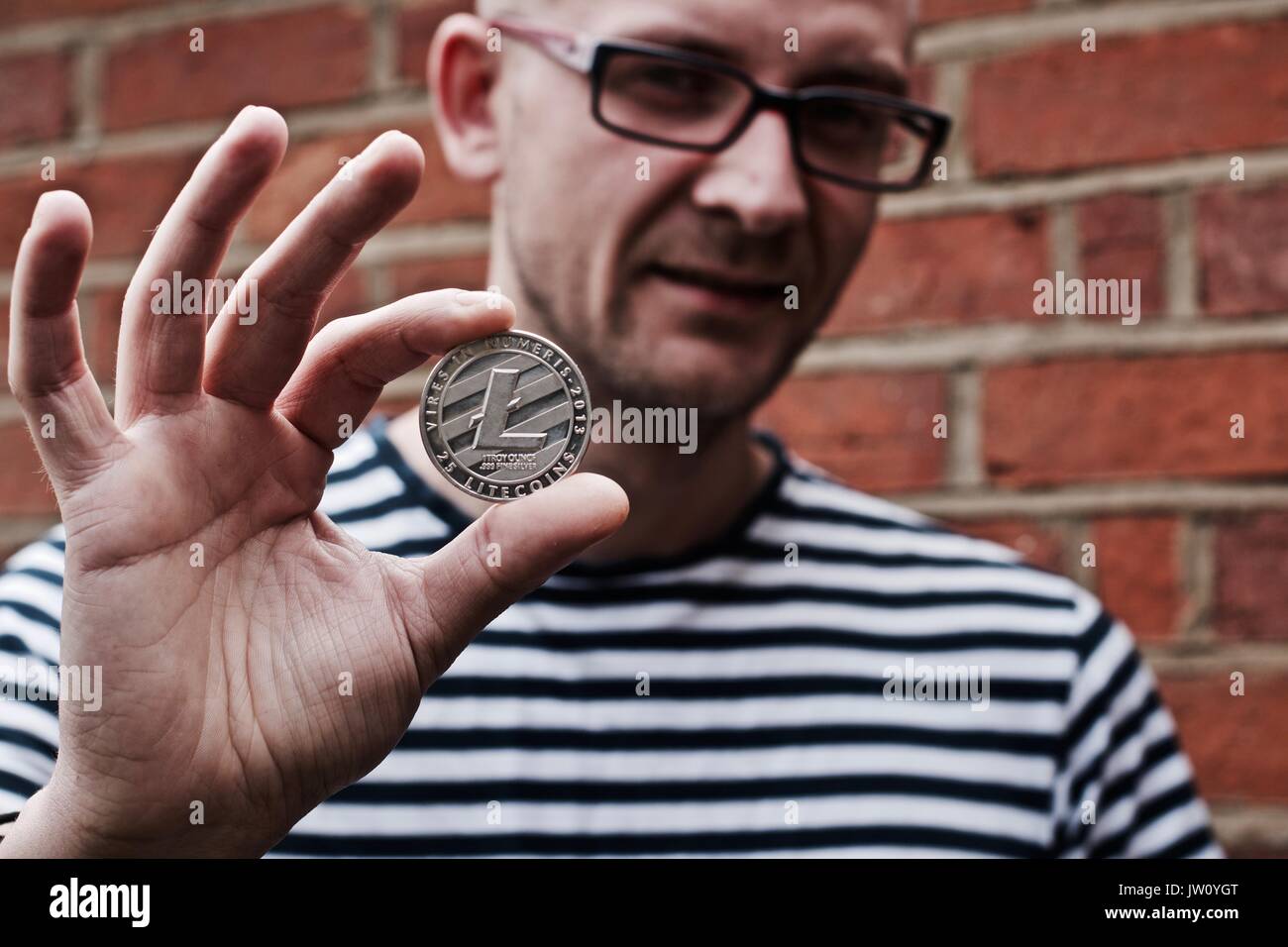 Coin holding human hand fingers hi-res stock photography and images - Alamy