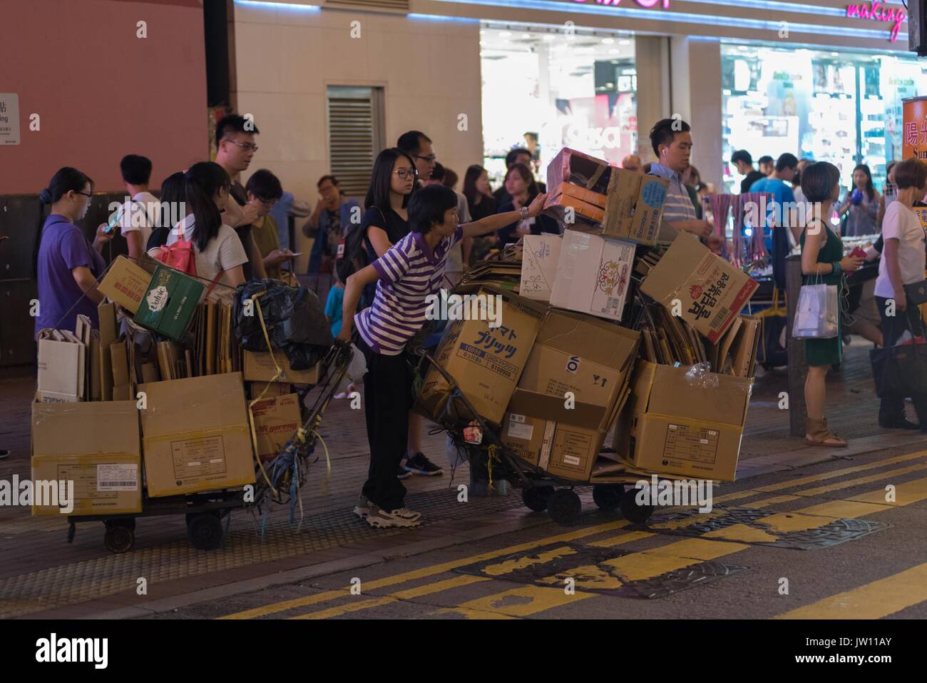 A "cardboard lady" stabilizes her load before crossing the street in ...