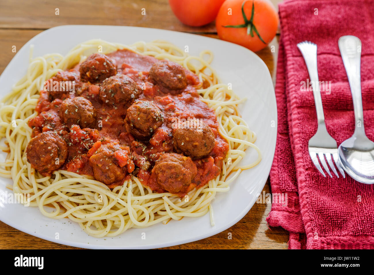 Spaghetti and Meatballs on a Square Plate with Tomatoes, fork and knife ...