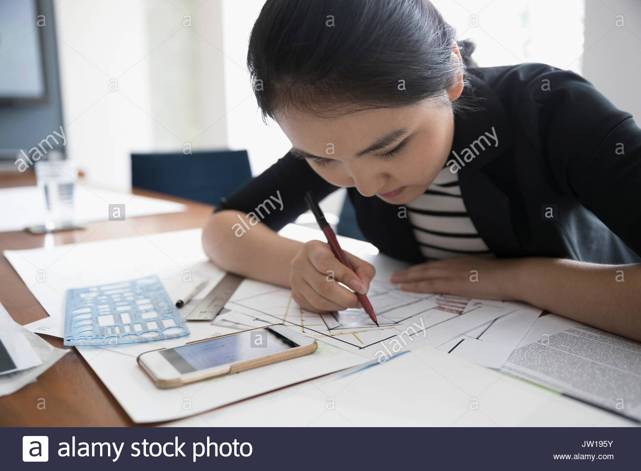 Dedicated female architect drafting blueprints in conference room Stock ...