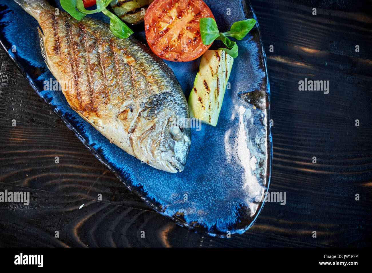Grilled Fish dish - roasted fish and vegetables jpg Stock Photo - Alamy