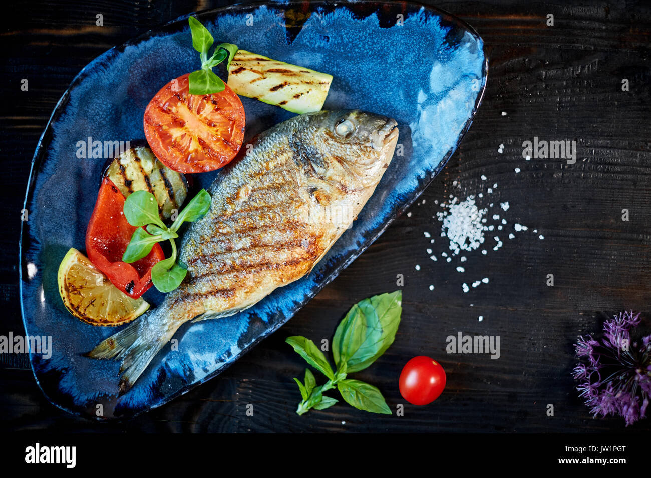 Grilled Fish dish - roasted fish and vegetables jpg Stock Photo - Alamy