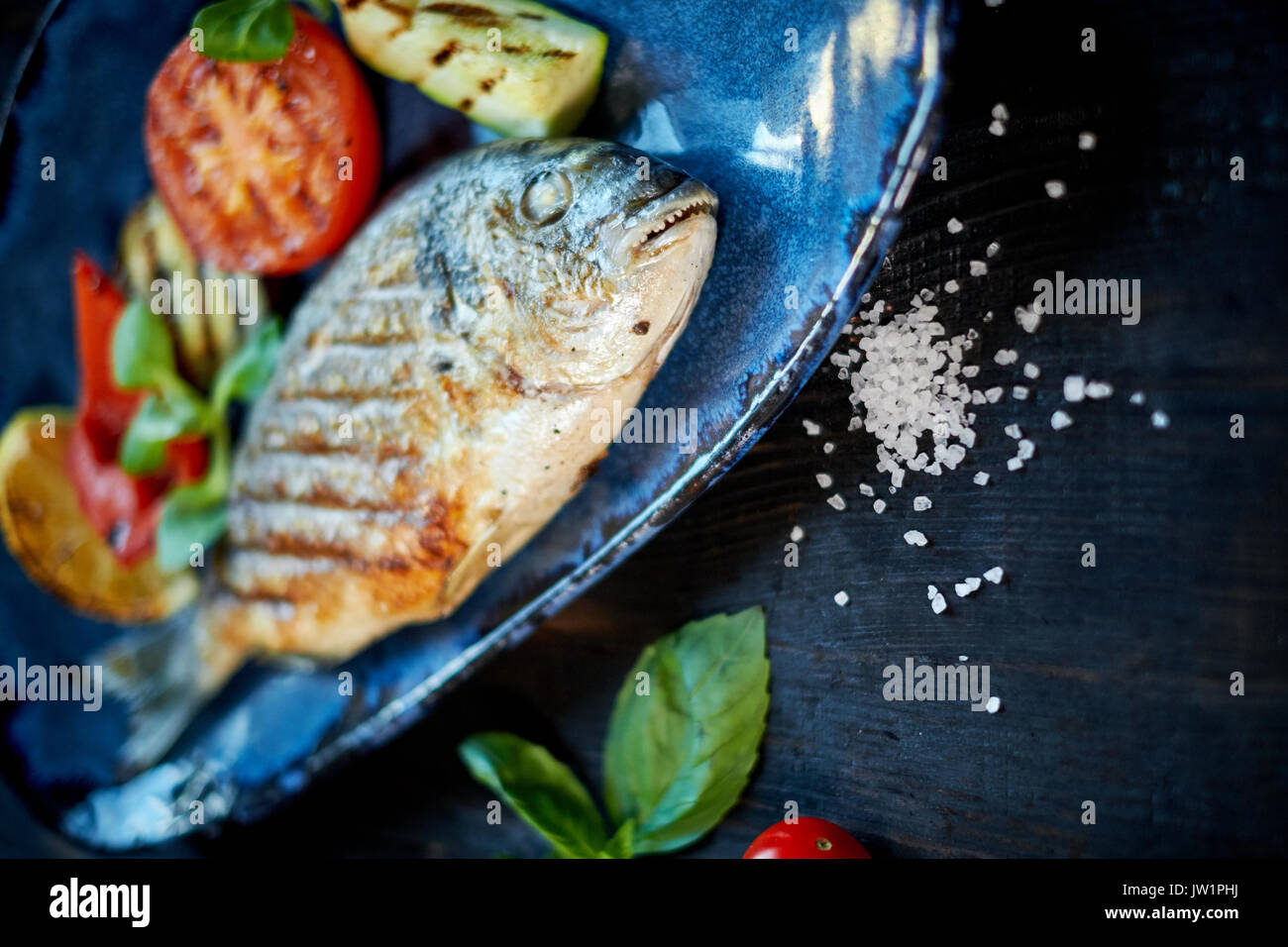Grilled Fish dish - roasted fish and vegetables jpg Stock Photo - Alamy