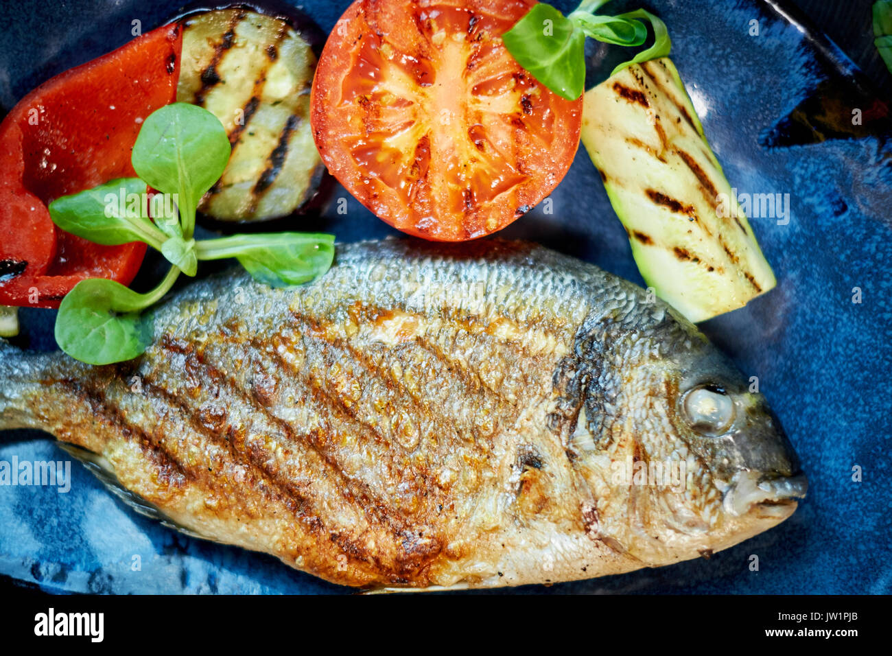 Grilled Fish dish - roasted fish and vegetables jpg Stock Photo - Alamy
