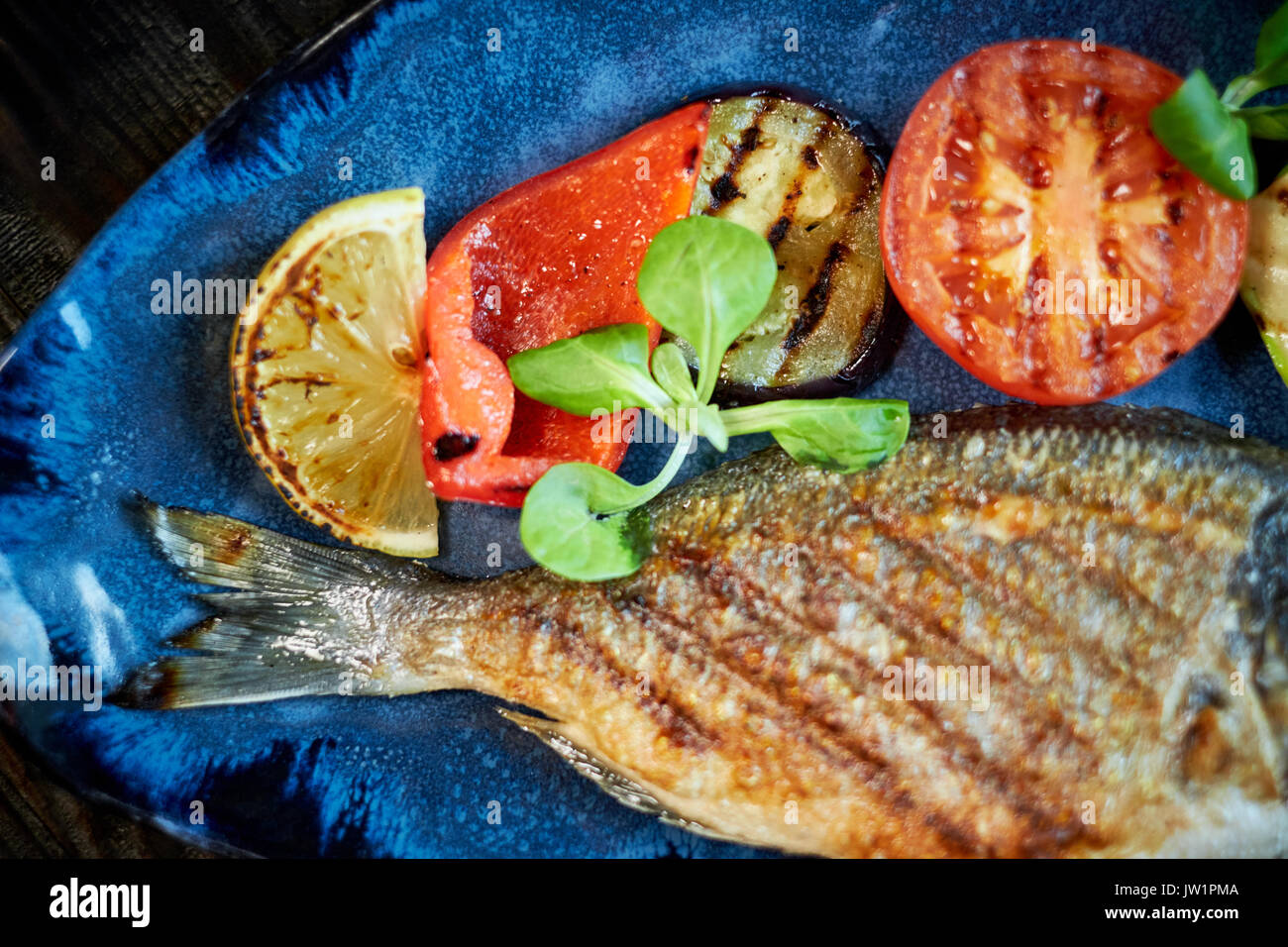 Grilled Fish dish - roasted fish and vegetables jpg Stock Photo - Alamy